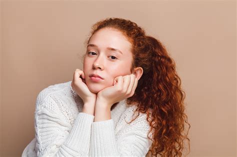 흰색 스웨터에 빨간 곱슬 머리 갈색 눈과 주근깨와 귀여운 소녀는 카메라를 본다 베이지 색 배경에 스튜디오에서 촬영 16 17 살에 대한 스톡 사진 및 기타 이미지 Istock