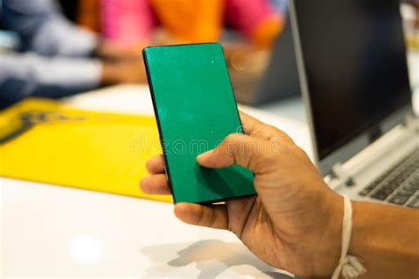Close Up Shot Of Employee Hands Using Green Screen Mobile Phone At Corporate Office Meeting