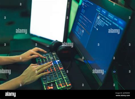 Unrecognizable Young Woman Sitting In A Gamer Armchair Typing On A Backlit Keyboard Hacking
