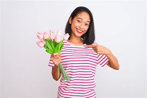 자신에게 손가락을 가리키는 깜짝 얼굴과 고립 된 흰색 배경 위에 서있는 장미꽃다발을 들고 있는 젊은 중국 여성 가리키기에 대한 스톡 사진 및 기타 이미지 Istock