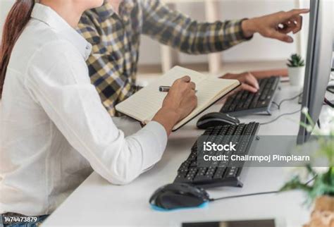 programmer menulis kode program dengan dua monitor dan mengerjakan