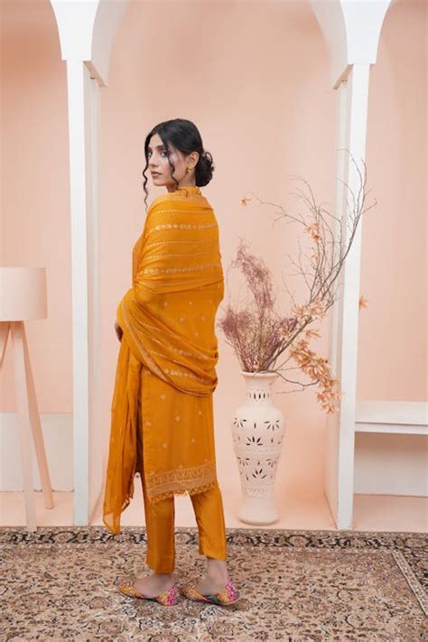 有关亞洲 伊斯兰艺术 优雅的服装 优雅的样子 传统披肩 传统服装 保持镇定 優雅 咖啡色頭髮的女人 地毯 垂直拍摄 女人 室內設計 室内环境 室内装饰 家居时尚