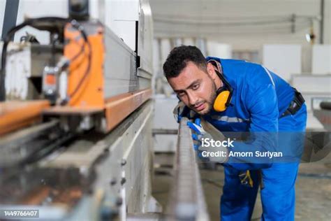 산업 공장에서 컨베이어 벨트 기계를 확인하는 남성 엔지니어 노동자 남성 기술자는 공장에서 안전 장갑과 균일 한 작업 유지 보수