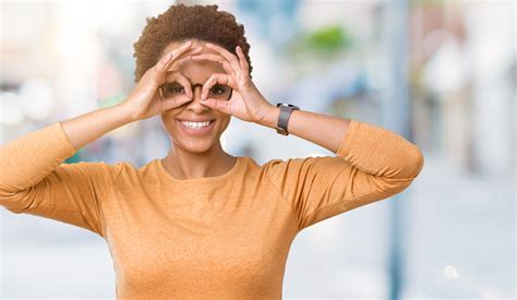 젊은 아름 다운 아프리카계 미국인 여자 안경을 착용 하 고 고립 된 배경 위에 쌍안경 처럼 혀를 내밀고 확인 제스처를 하 고 손가락을 통해 보는 눈 미친 표정 곱슬 머리에