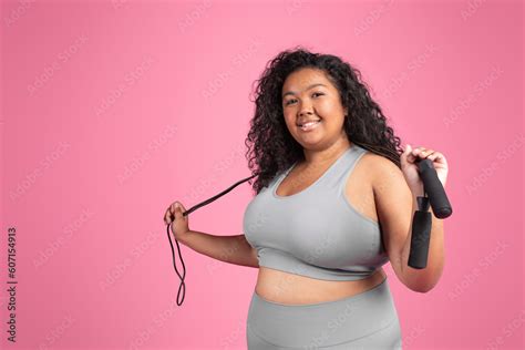 Satisfied Black Woman Plus Size In Sportswear With Skipping Rope Ready To Training On Pink
