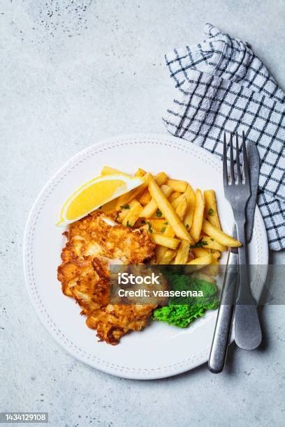 피쉬 앤 칩스 감자 튀김과 으깬 완두콩을 흰 접시 회색 배경에 반죽으로 대구 물고기 영어 음식 개념 피쉬 앤 칩스에 대한 스톡