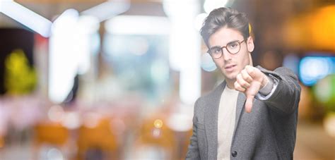 불행 하 고 화가 거절을 보여주는 제스처 반대와 부정적인 보고 격리 된 배경 위에 안경을 쓰고 젊은 비즈니스 사람 나쁜 식입니다