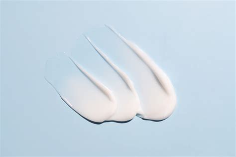파란색 배경에 흰색 크림의 질감입니다 모이스처 라이저의 얼룩이 닫힙니다 로션 견본 뷰티 스킨 케어 제품 얼룩 얼룩 파란색 배경에 Spf 자외선 차단제 크림 샘플 보습제에