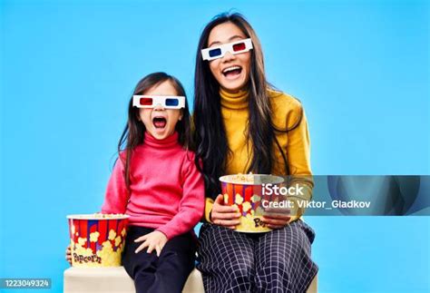 놀란 어머니와 그녀의 어린 딸에 3d 안경 과 팝콘 보고 영화 위에 푸른 배경 2명에 대한 스톡 사진 및 기타 이미지 2명