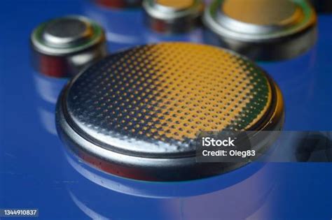 빨간색과 주황색으로 강조 표시된 다양한 크기의 작은 버튼 배터리는 파란색 배경에 있습니다 클로즈업 금속에 대한 스톡 사진 및 기타 이미지 Istock