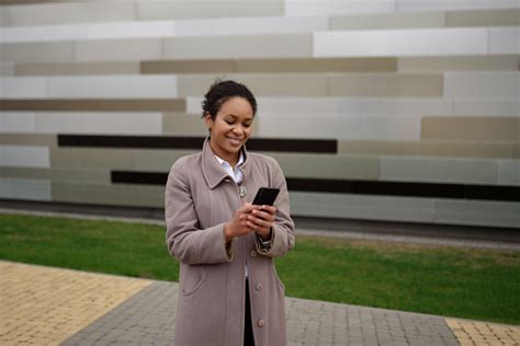 사무실 건물 근처에서 휴대 전화를 사용하는 아프리카 계 미국인 여성이 인터넷의 메시지에 응답합니다 은행업무에 대한 스톡 사진 및 기타 이미지 Istock