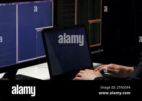 Hacker In Hood Cracking Code Using Laptop And Computers From His Dark Hacker Room Stock Video