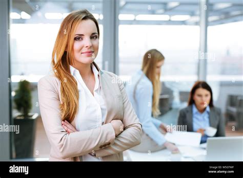 Smart Female Manager Standing In An Office And Looking Straight At The