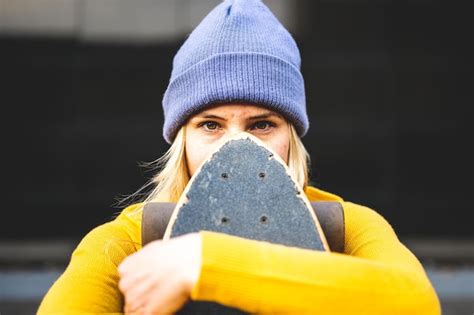 Mirada intensa del rostro de una mujer joven que usa la generación z de skate y el estilo de
