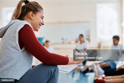 학교 체육관에서 체육 수업 중에 메모를 하는 행복한 스포츠 교사 건강한 생활방식에 대한 스톡 사진 및 기타 이미지 건강한 생활방식 계획 고등학교 이하 Istock