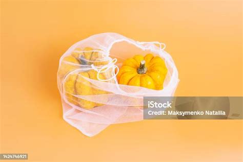 오렌지색 배경에 직물의 메쉬 가방에 호박의 다른 종류 가을 개념 공간을 복사합니다 호박의 구성 행복한 추수 감사절야채 가을 음식 개념 가을 할로윈 호박 0명에 대한 스톡