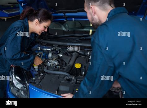 Team of mechanics examining car engine Stock Photo - Alamy