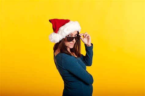 노란색 배경과 선글라스가있는 산타 클로스 모자를 쓴 갈색 머리 소녀 35 39세에 대한 스톡 사진 및 기타 이미지 35 39세 귀여운 노란색 배경 Istock