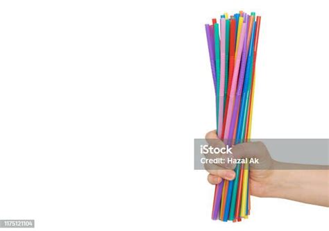 흰색 배경에 고립 된 파티 유해한 일회용 일회용 플라스틱 개체 개념으로 다채로운 음료 빨대를 들고 손의 클로즈업 밀짚에 대한