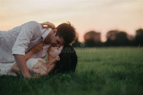 Un Couple Affectueux Ment Et Fait L Amour Parmi La Pelouse Au Coucher