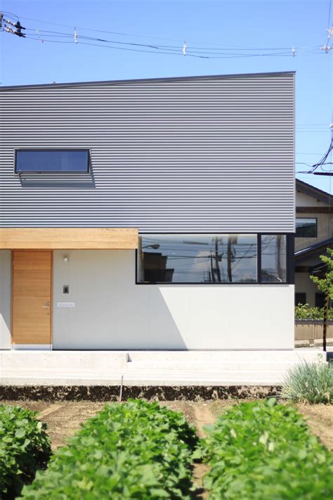 外観｜グレーの外壁に木製の庇と玄関ドアが良い差し色に｜設計：mma Небольшие домики Лофт дом Дом