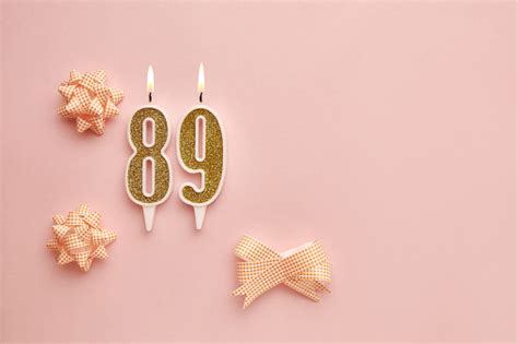 축제 장식이 있는 파스텔 핑크 배경에 숫자 89가 있는 양초 생일 축하 촛불 생일 기념일 중요한 날짜 휴일을 축하하는 개념입니다 복사 공간 기치 1에 대한 스톡 사진 및
