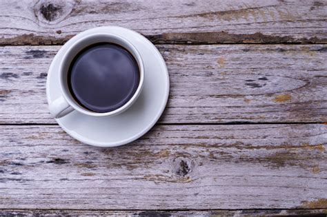 오래된 나무 테이블에 뜨거운 아메리카노 커피 접시에 커피 한 잔 아메리카노 블랙 커피 나무 바닥에 커피 컵 오후는 커피를 마시는 가장 좋은시기입니다 0명에 대한 스톡 사진