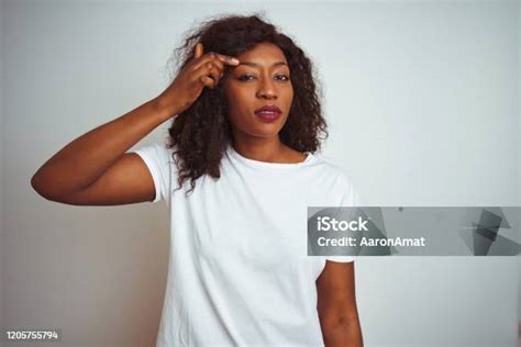 이마에 여드름에 불행을 가리키는 고립 된 흰색 배경 위에 서 T 셔츠를 입고 젊은 아프리카 계 미국인 여성 블랙 헤드의 추한 감염 여드름과 피부 문제 T 셔츠에 대한 스톡