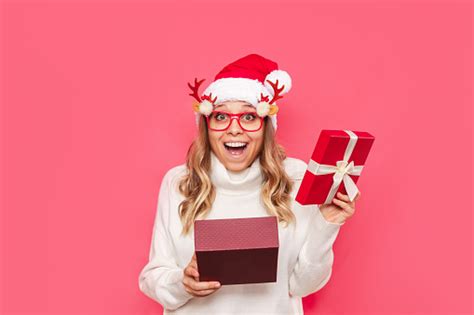 흰색 따뜻한 스웨터와 빨간 산타 모자를 쓴 한 젊은 여성이 받은 선물에 만족합니다 크리스마스와 새해 컨셉 30 34세에 대한 스톡 사진 및 기타 이미지 Istock
