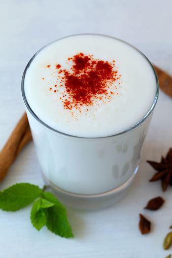 흰 배경에 고추와 신선한 녹색 민트와 클로즈업 Lassi 음료 테이블에 프로바이오틱스와 디저트 요구르트 또는 우유 향신료가