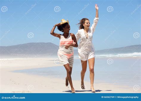 Due Giovani Donne Che Ridono E Che Giocano Sulla Spiaggia Immagine Stock Immagine Di Copia