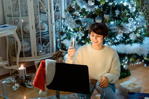 가상 전화로 친구 나 가족과 이야기하는 동안 샴페인을 마시는 여성 크리스마스 온라인 축하 새해 복 많은 온라인 파티 노트북에서 화상 회의 채팅 선택적 초점 12월에 대한