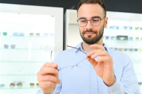 Man Chooses Glasses For Vision Correction In An Ophthalmology Salon
