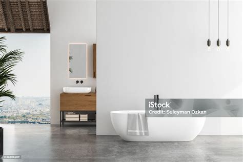 콘크리트 바닥 도시 전망의 창문 흰 벽 큰 욕조 수직 거울과 나무 화장대가 있는 흰색 세면대가 있는 세련된 욕실 인테리어 3d 렌더링 복사 공간 0명에 대한 스톡 사진 및