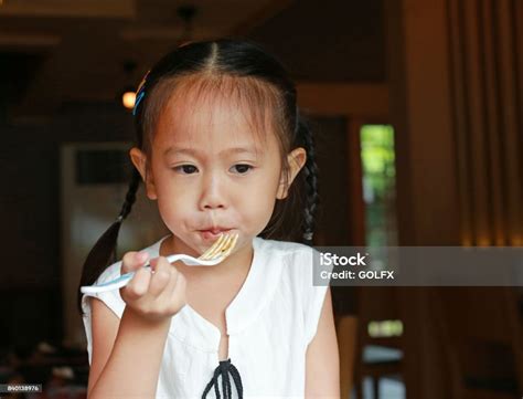 레스토랑에서 점심 테이블에 맛 있는 음식을 먹고 그녀의 손에 플라스틱 포크를 들고 아시아 아이 여자를 닫습니다 건강한 생활방식에