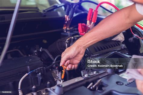 오픈 후드와 정비사 수리 자동차 오픈 후드와 차에 정비사 검사 레벨 모터 오일의 측면보기 배터리의 전압을 확인하기 위한 흐릿한