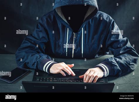 Anonymous Hacker Programmer Uses A Laptop To Hack The System Stealing