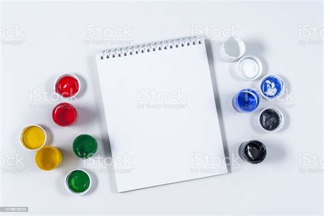 텍스트 공간이 있는 흰색 배경에 대한 예술적 모형 그리기 도구 컬러 아크릴 페인트 페인트 브러시 및 빈 메모장 레이아웃입니다 액세서리가 있는 아티스트의 테이블 가정 교육 및