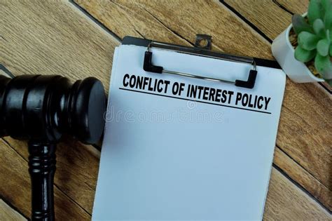 Concept Of Conflict Of Interest Policy Write On Paperwork Isolated On Wooden Table Stock Image