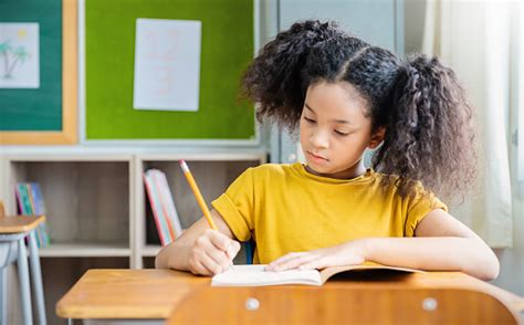 초등학교 교실 책상에서 글을 쓰는 어린 학생의 초상화 초등학교에서 시험을 하고 있는 아프리카 학생 소녀 아이들은 교실에서 메모를 작성합니다 교육 지식 배너 교육에 대한 스톡