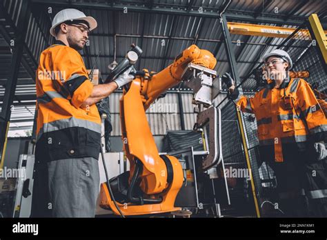 Engineer Team Service Robot Welding Working In Automation Factory People Worker In Safety Suit