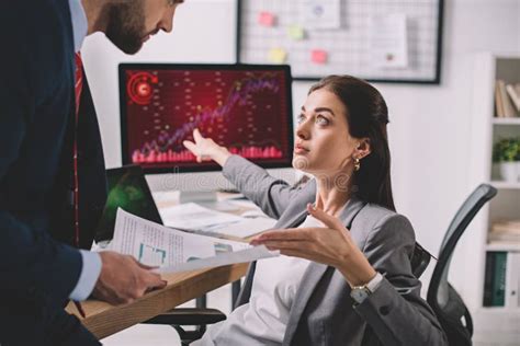 View Of Data Analyst Pointing On Computer Monitor With Charts Near