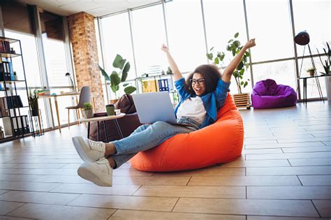 활기찬 장식으로 꾸며진 현대적이고 창의적인 사무실 공간에서 일하면서 성공을 축하하는 젊은 전문직 여성 20 24세에 대한 스톡 사진 및 기타 이미지 Istock