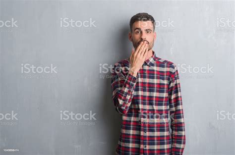 침묵 비밀 개념에에서 무서 워 하는 젊은 성인 남자 손으로 실수 두려움의 표현에 대 한 수치와 충격 회색 그런 지 벽 커버 입 서 가리기에 대한 스톡 사진 및 기타 이미지