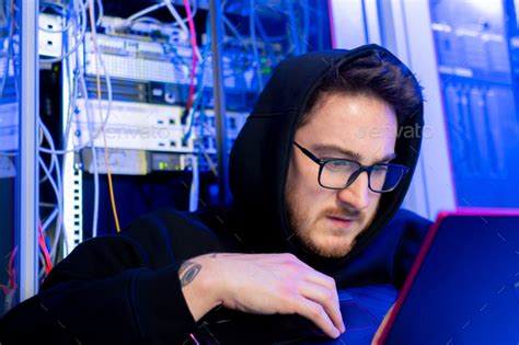 Concentrated Hooded Hacker In Data Center Hacking Software System