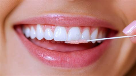 A Close Up Of A Woman Flossing Her Teeth Highlighting The Importance Of Oral Hygiene And Daily