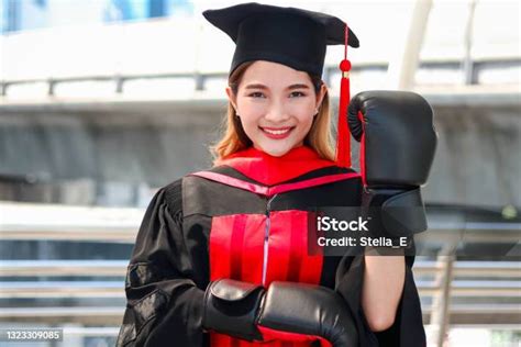 행복한 미소 졸업 한 여자 학생 온난화 광장 학술 모자 모자 빨간 권투 장갑 또는 미트 펀치 삶에 대한 은유 인생은 졸업식 날에
