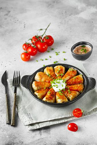 러시아 박제 양배추 롤은 토마토 녹색 양파와 회색 배경에 내 열 블랙 요리의 사 워 크림과 함께 제공 됩니다 음식 사진 0명에