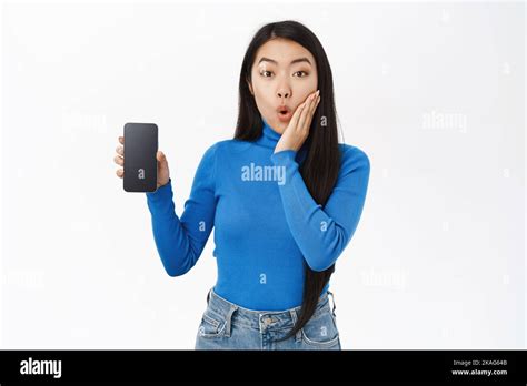 Surprised Asian Woman Shows Her Mobile Phone Screen Gasps With Impressed Face Stands Over