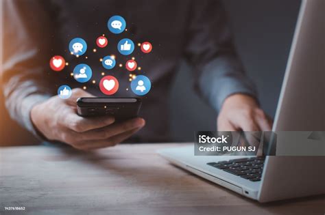 가상 빨간색 하트와 파란색 이모티콘 소셜 미디어 아이콘으로 스마트 폰에서 채팅 및 알림 홀로그램으로 휴가 중에 스마트폰을 사용하는 남자 소셜 미디어 및 디지털 온라인 개념